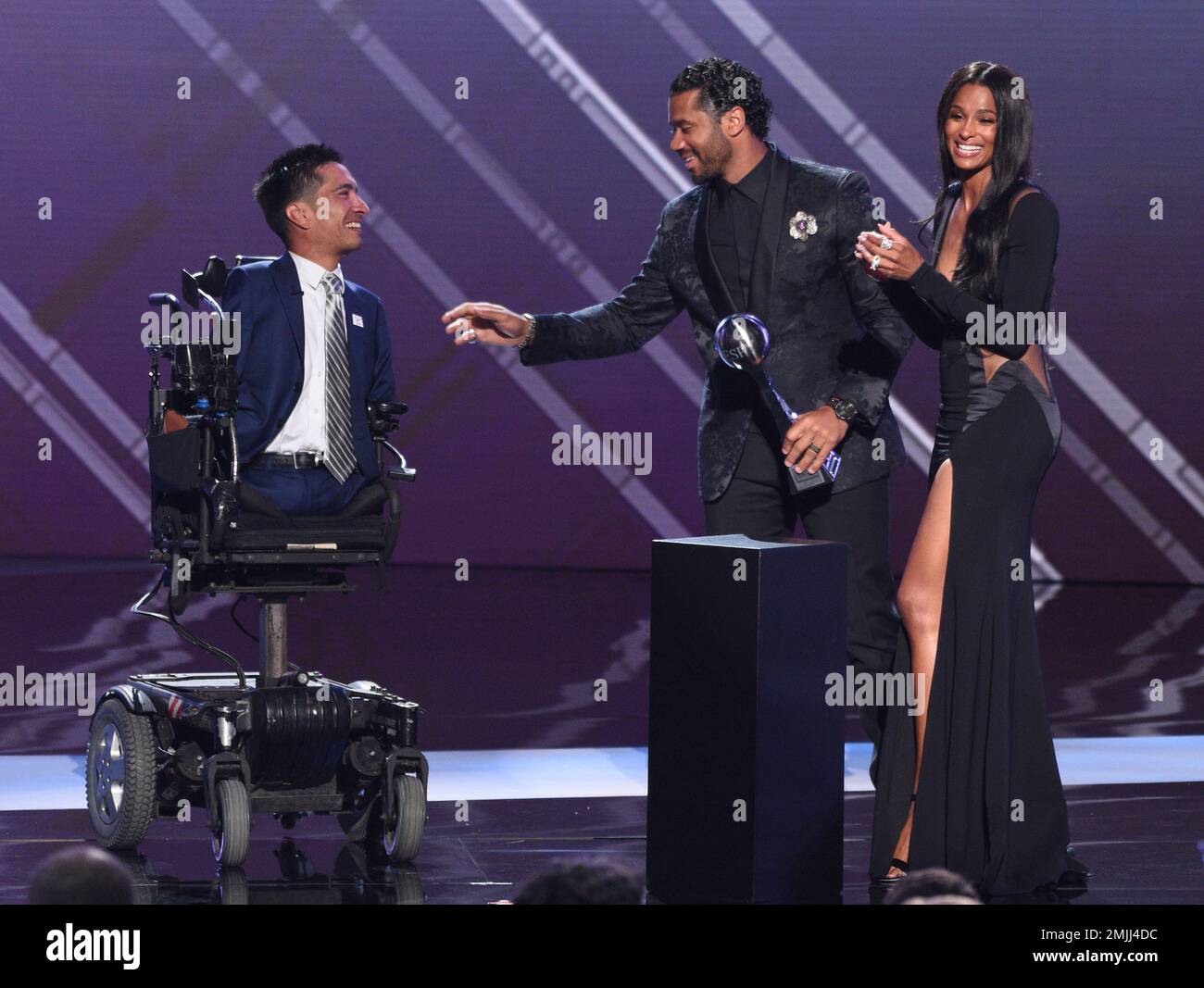 Russell Wilson, center, and Ciara, right, present the Jimmy V award for ...