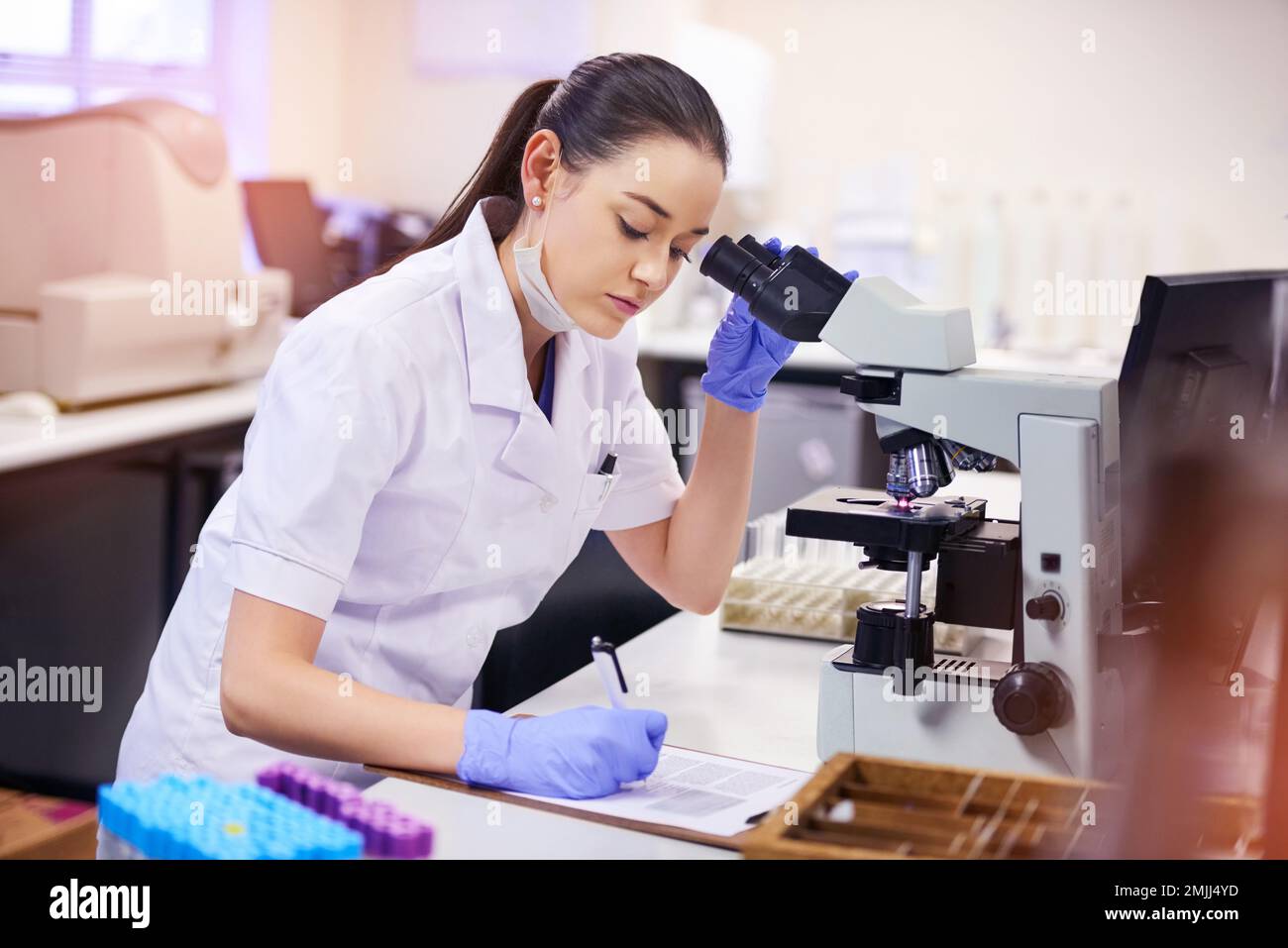 Interpreting results as she finds them. a young scientist taking notes ...