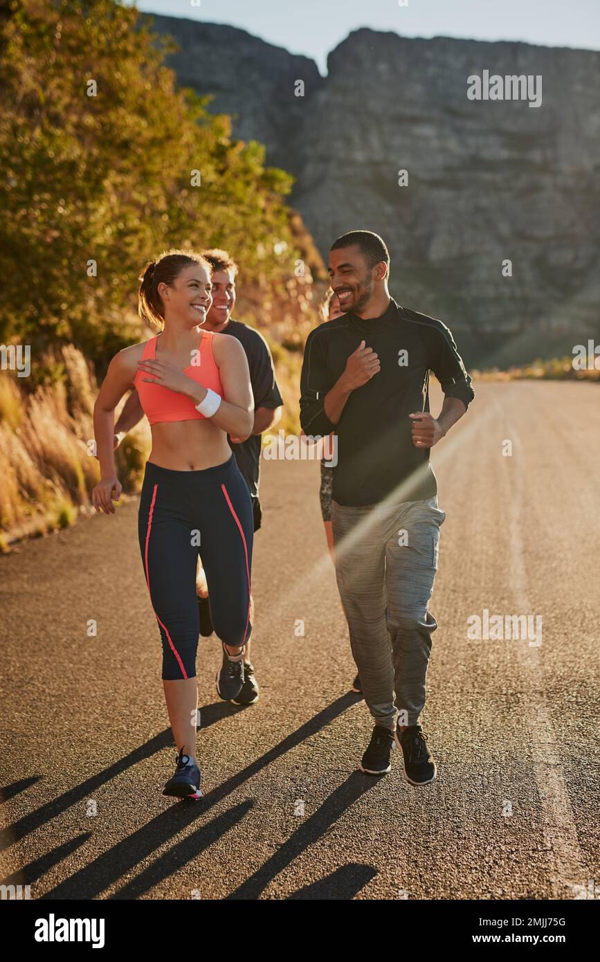 We rely on each others strengths. a fitness group running along a rural ...