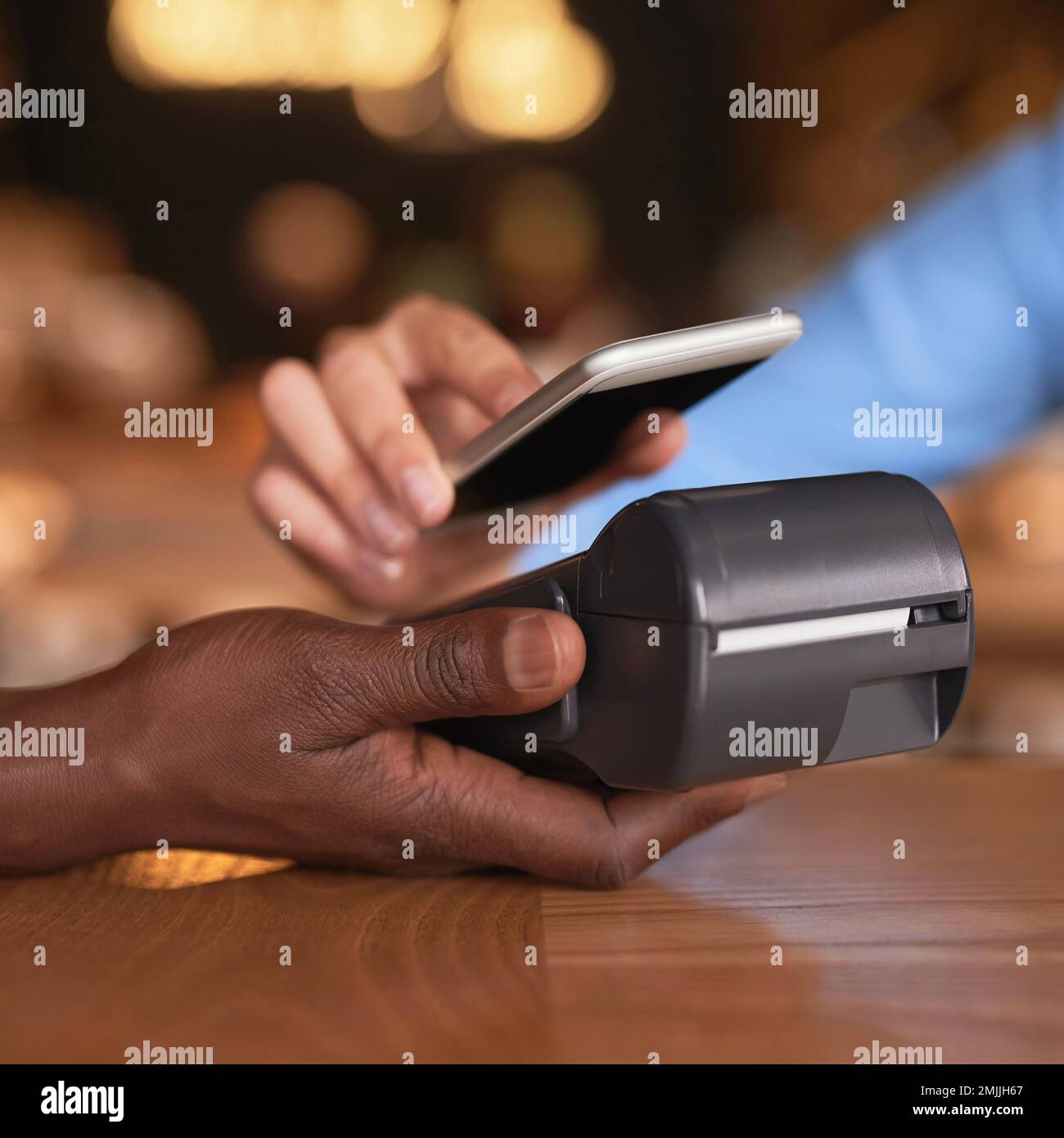 Paying with a single tap. an unrecognizable woman making payment in a ...