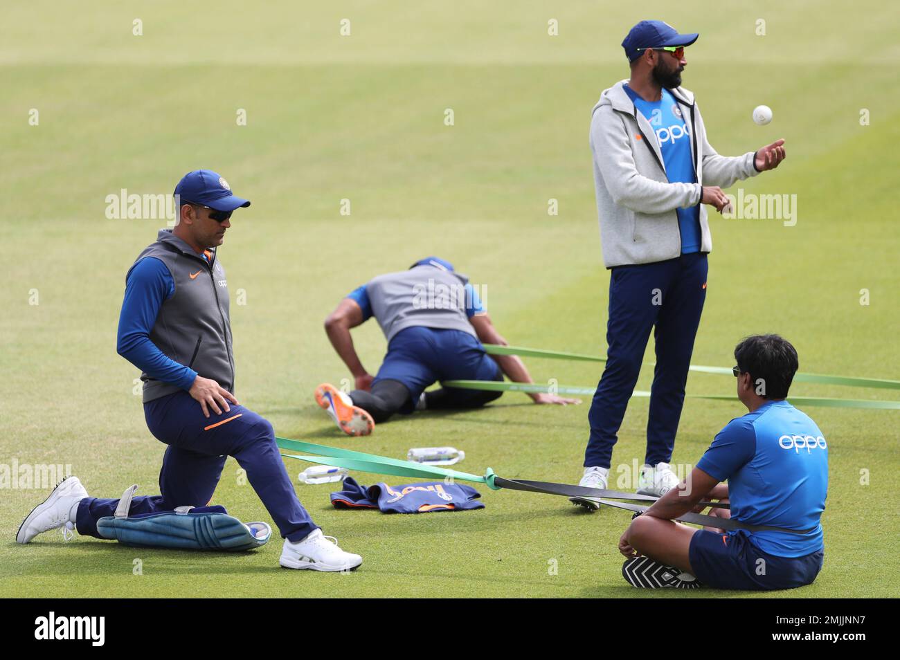 India's MS Dhoni, left, performs stretching exercises during a training ...