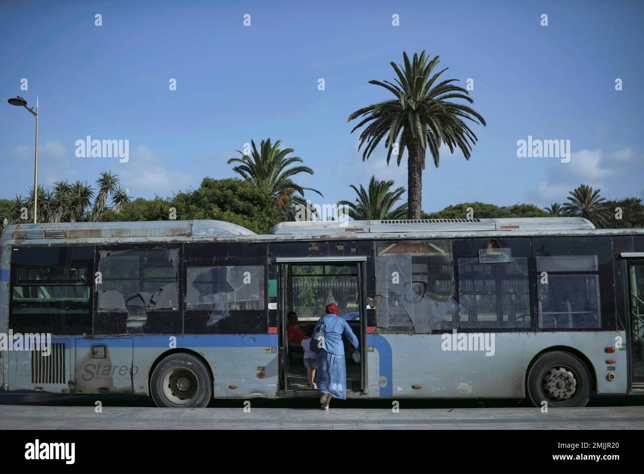 A woman steps into a public bus at a station near the old Medina in ...