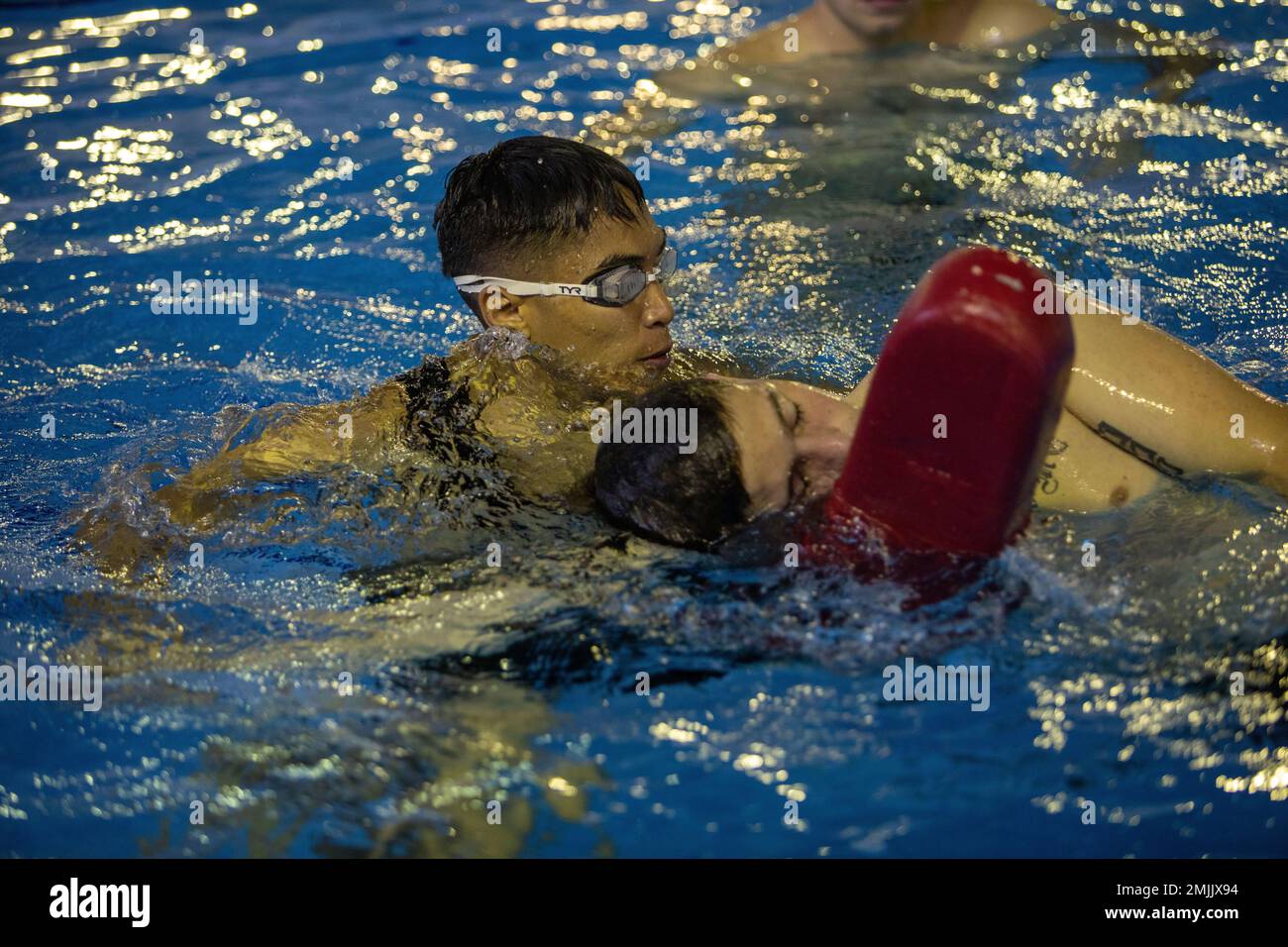 U.S. Marine Sgt. Nathan Juarez, uses a floatation device to keep Cpl ...