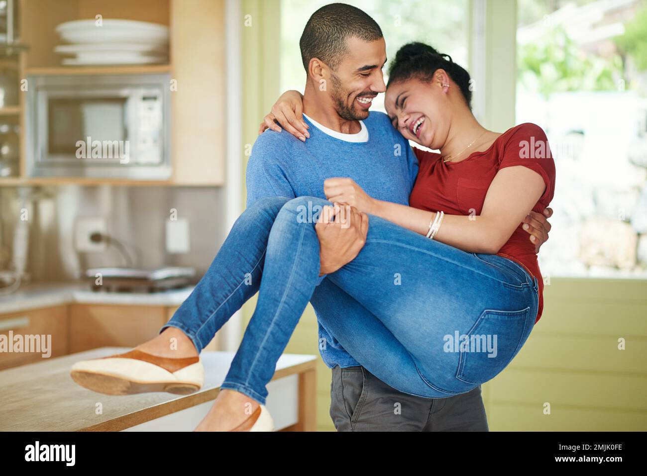 Where to. a handsome young man lovingly carrying his wife through their ...