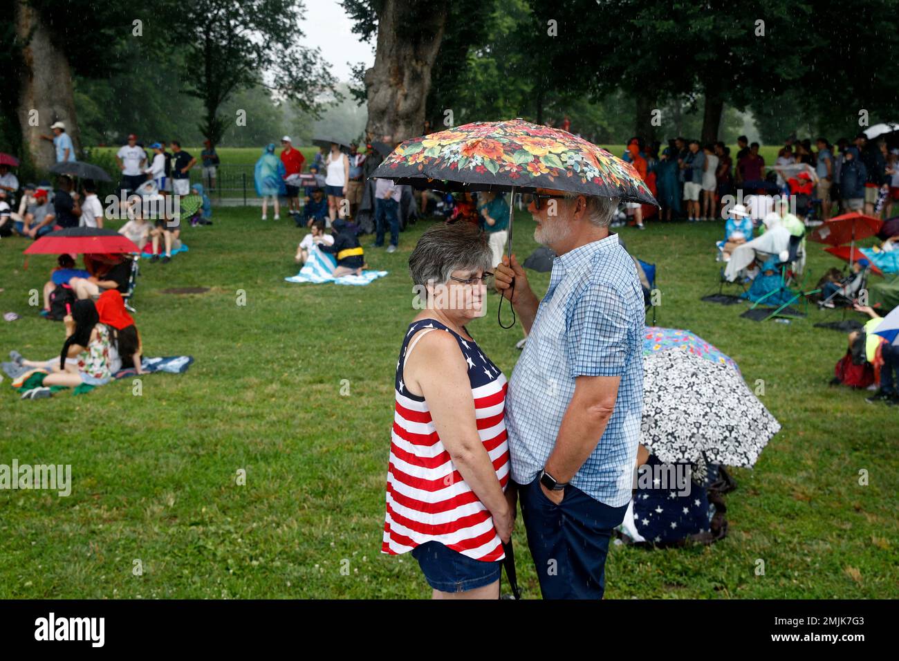 Debbie Barnett, left, of Raleigh, N.C., shares an umbrella with her ...
