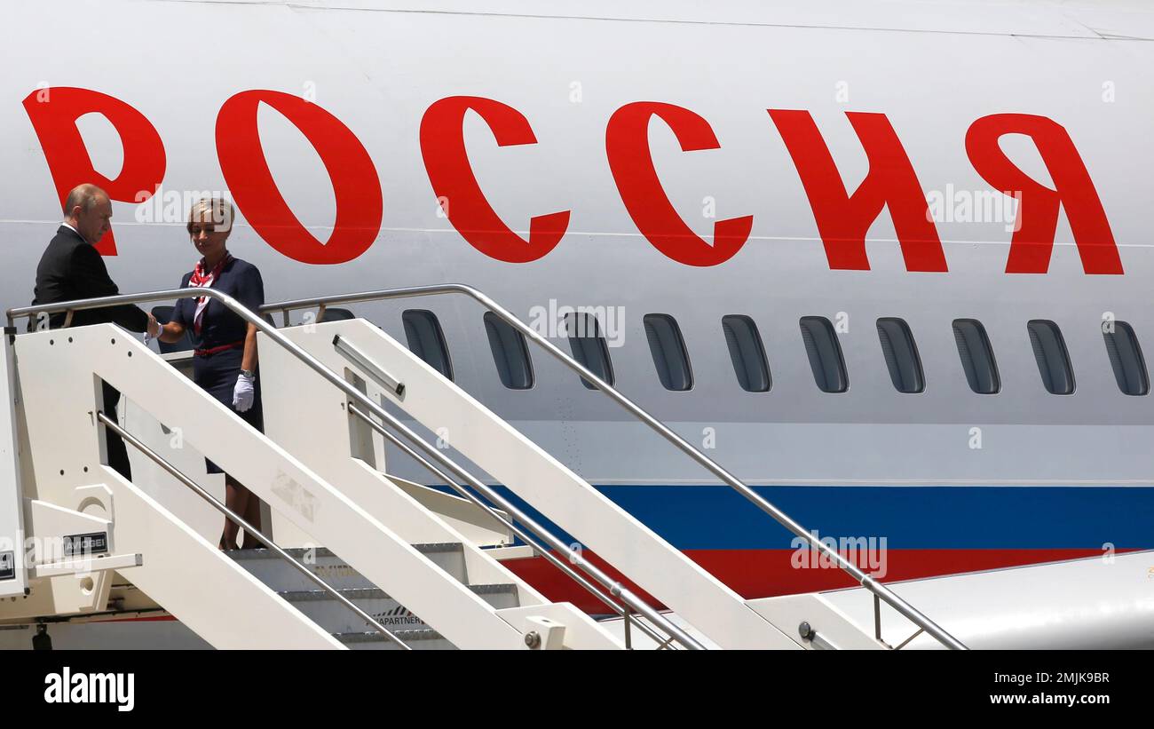 Russian President Vladimir Putin, left, steps off the plane as he ...
