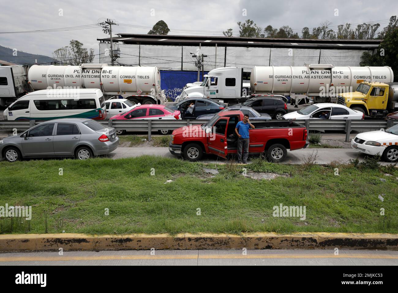 Drivers wait in and around vehicles that have already been stopped for ...