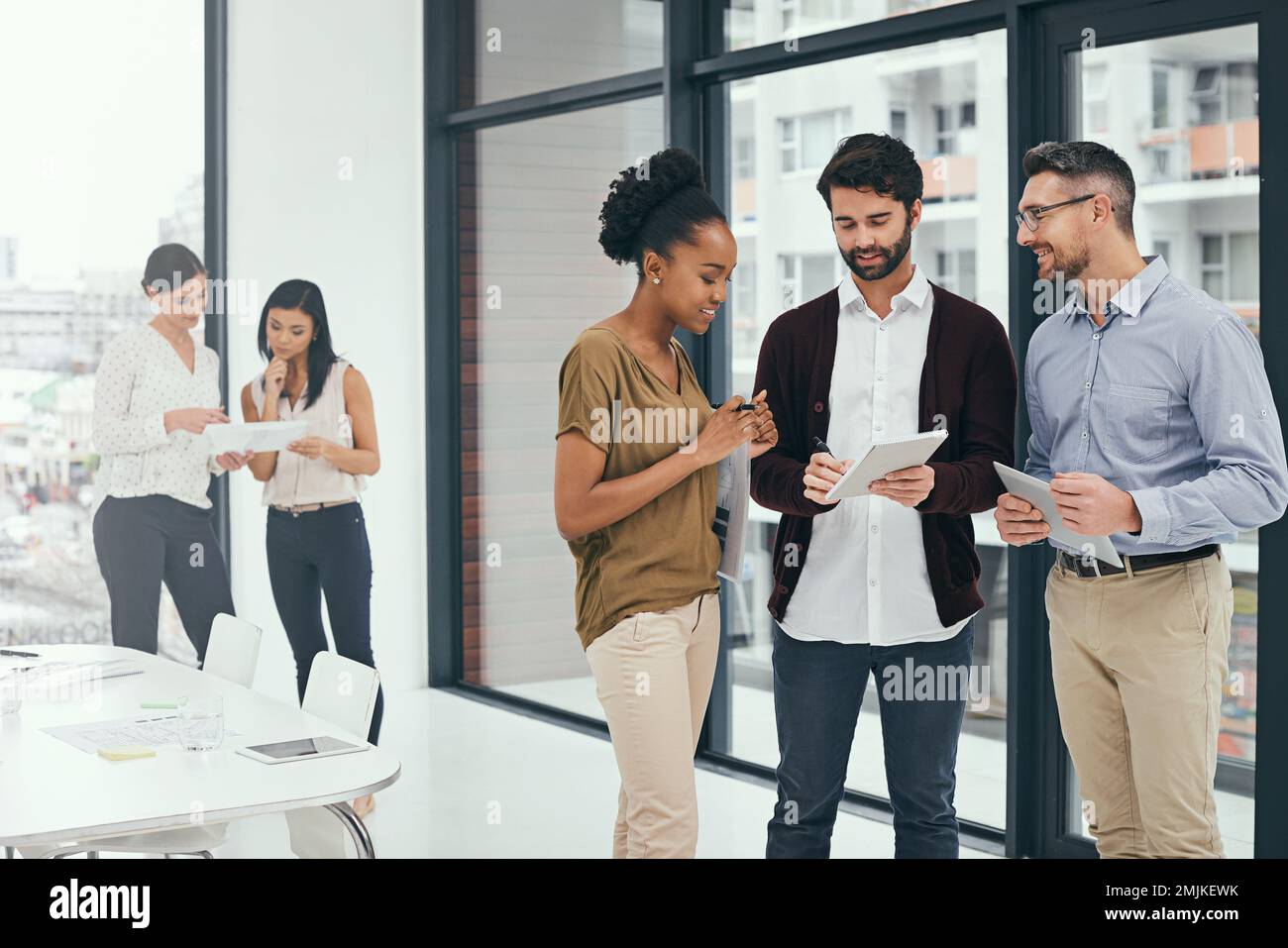 Consulting their notes. a group of colleagues having a discussion in an ...