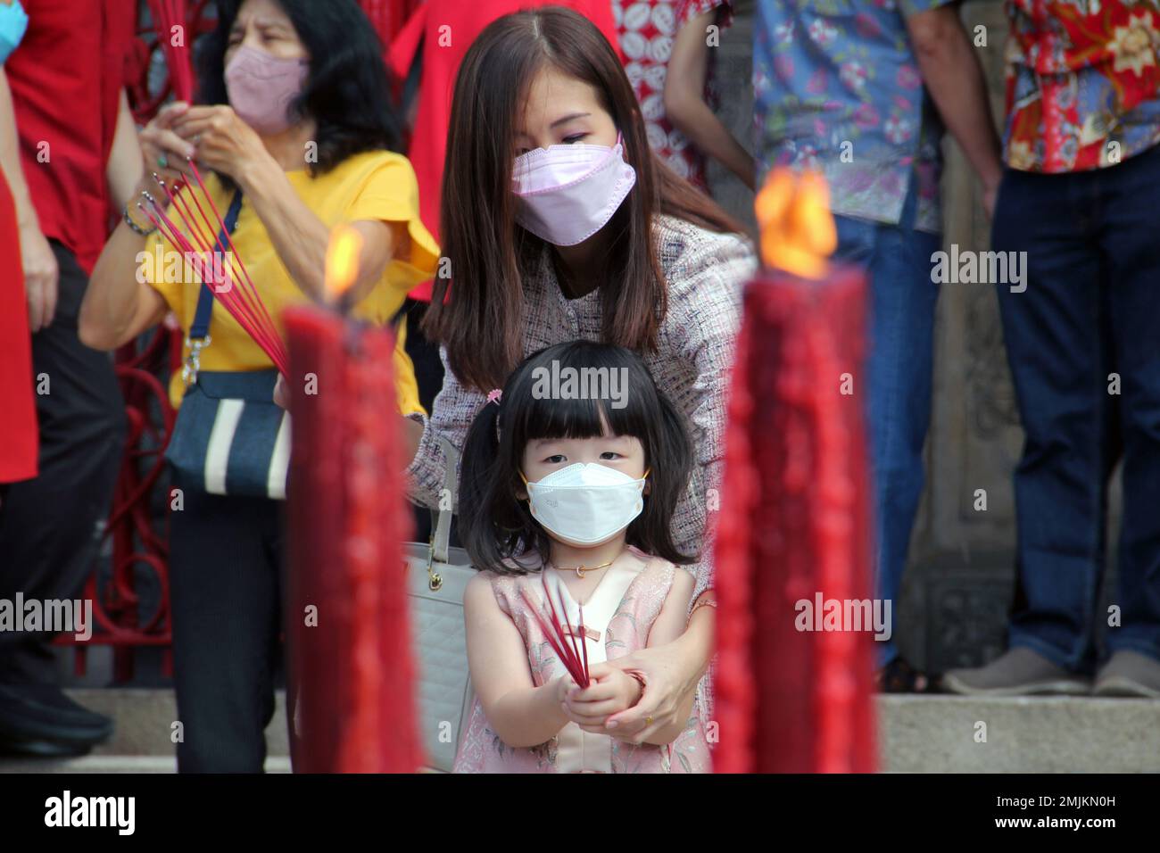 A mother directs her child to worship in front of the Satya Budhi ...