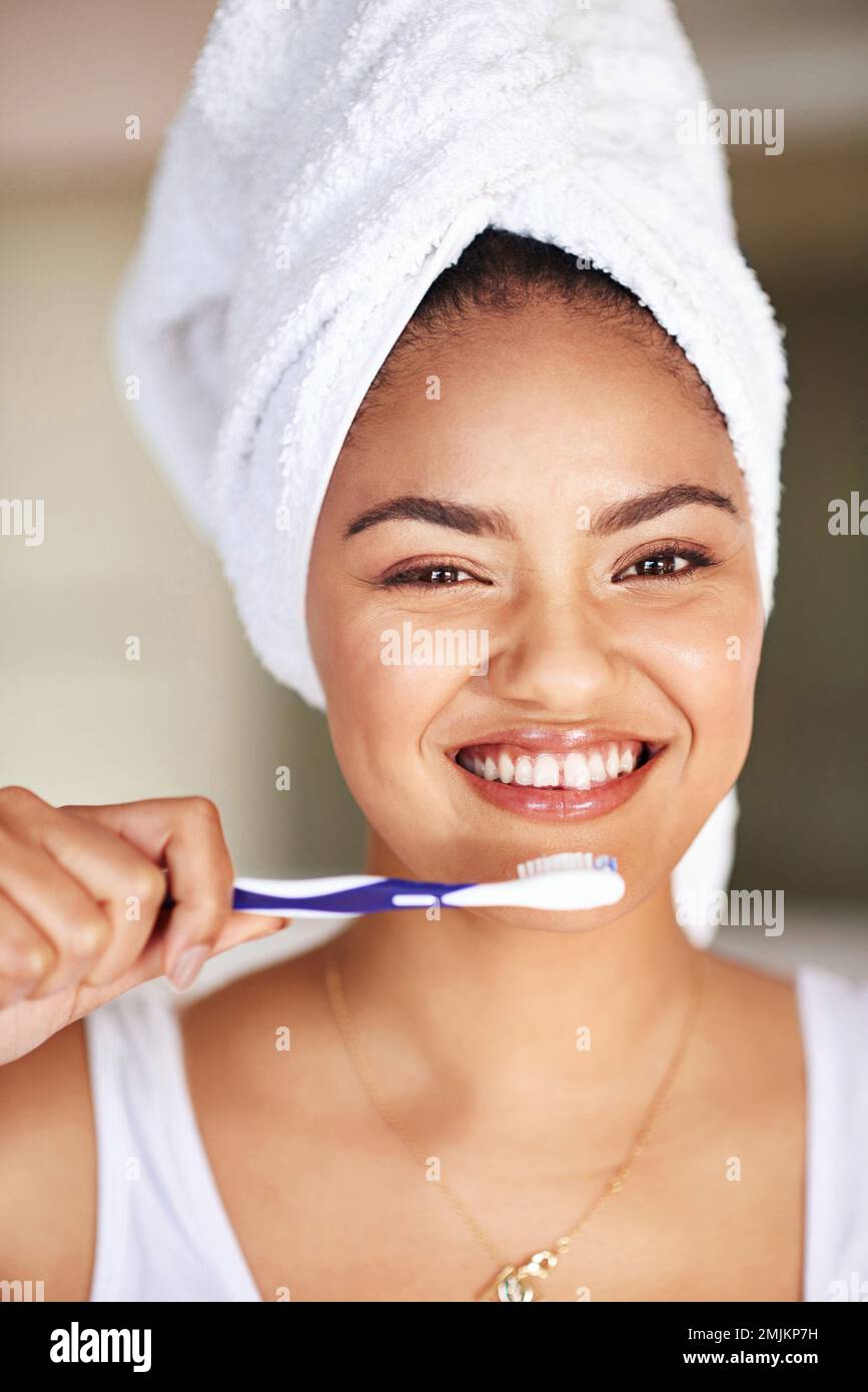 Got To Get Them White And Bright Portrait Of A Young Woman Brushing Her Teeth In The Bathroom