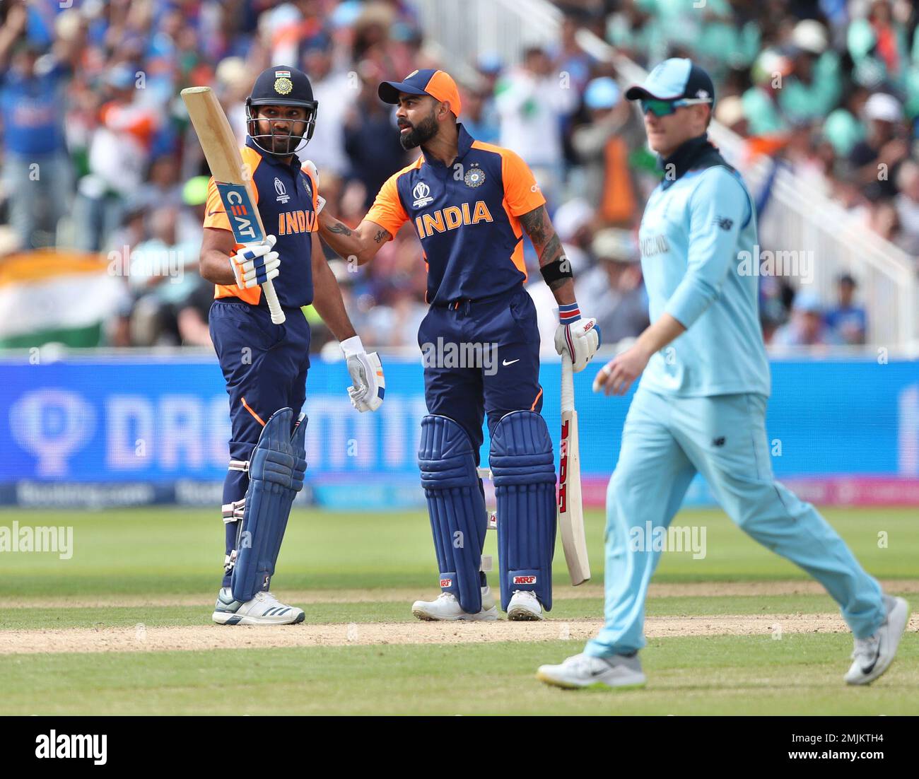 India's Rohit Sharma, left, raises his bat to celebrate scoring fifty ...