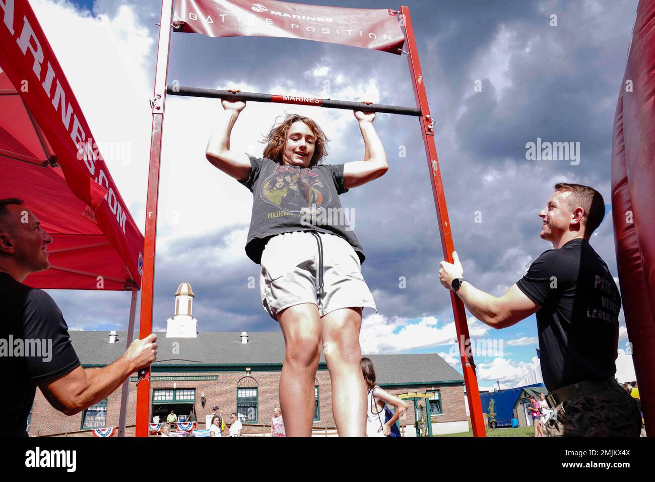 An attendee participates in pull-ups with U.S. Marines assigned to ...