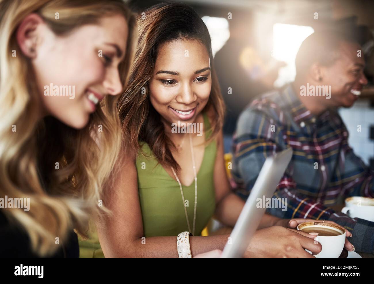 Technology that brings people closer. two friends using a tablet while ...