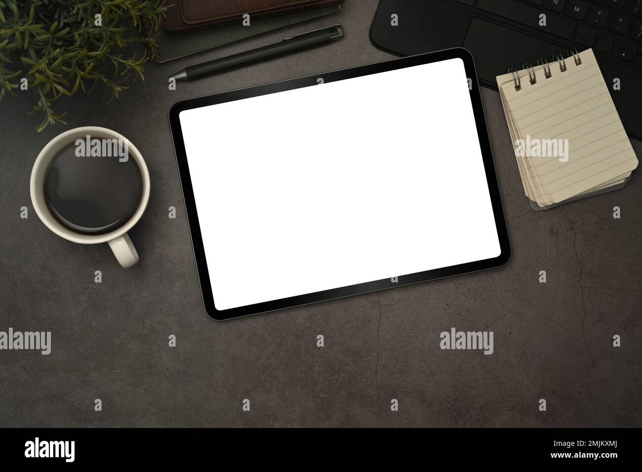 Digital tablet with blank display, cup of coffee and notepad on black ...