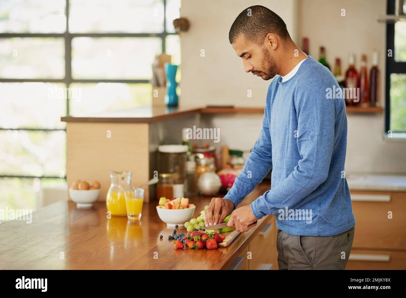 Taking control of his health. a young man preparing a healthy snack at ...