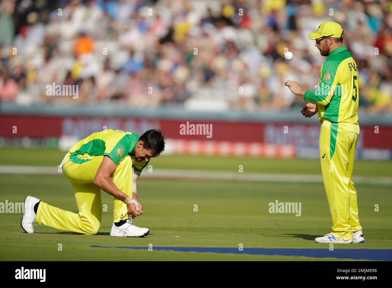 Australia's Mitchell Starc, left puts on his new set of studded shoes ...