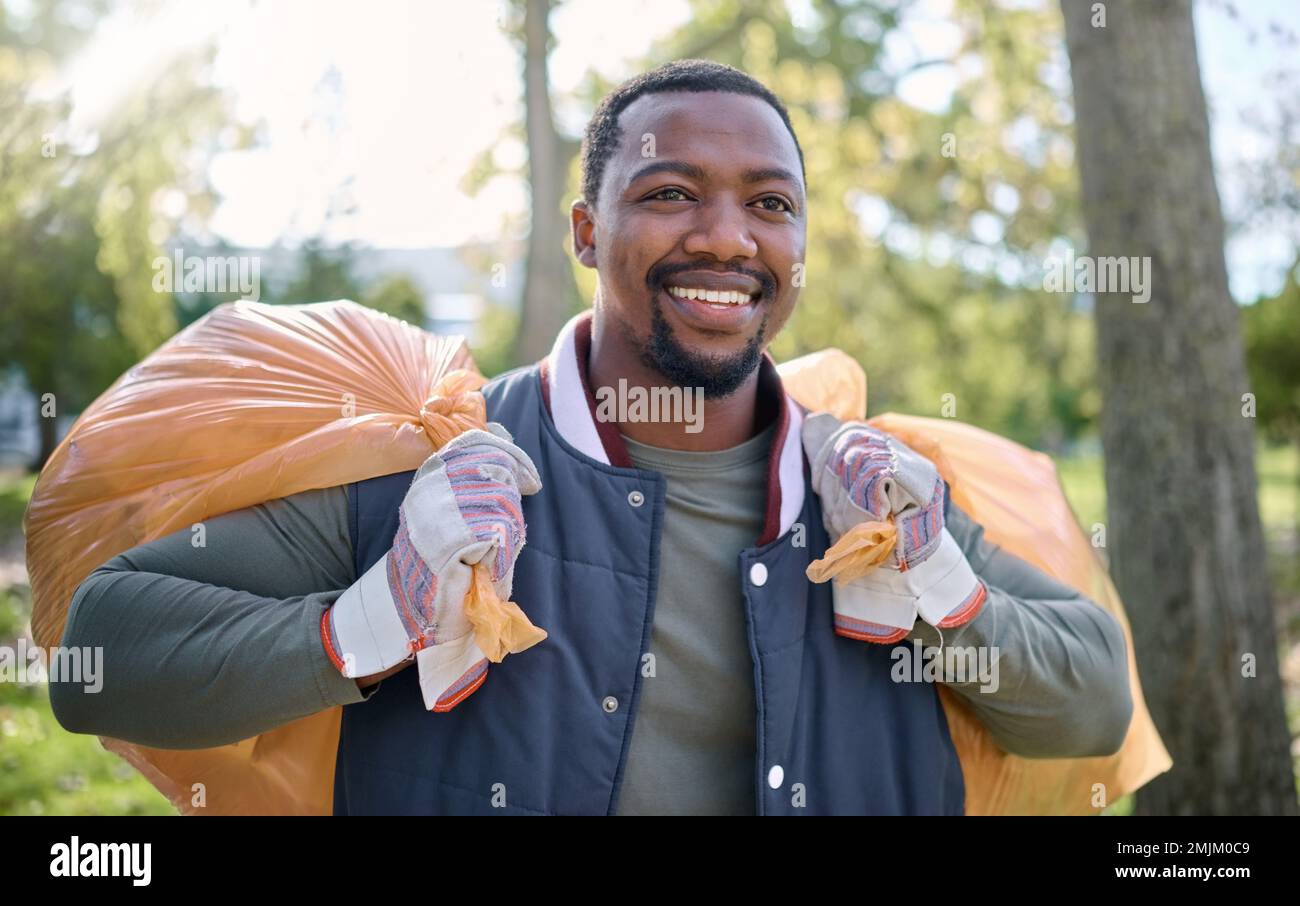 Volunteer, community service and black man cleaning park with garbage ...