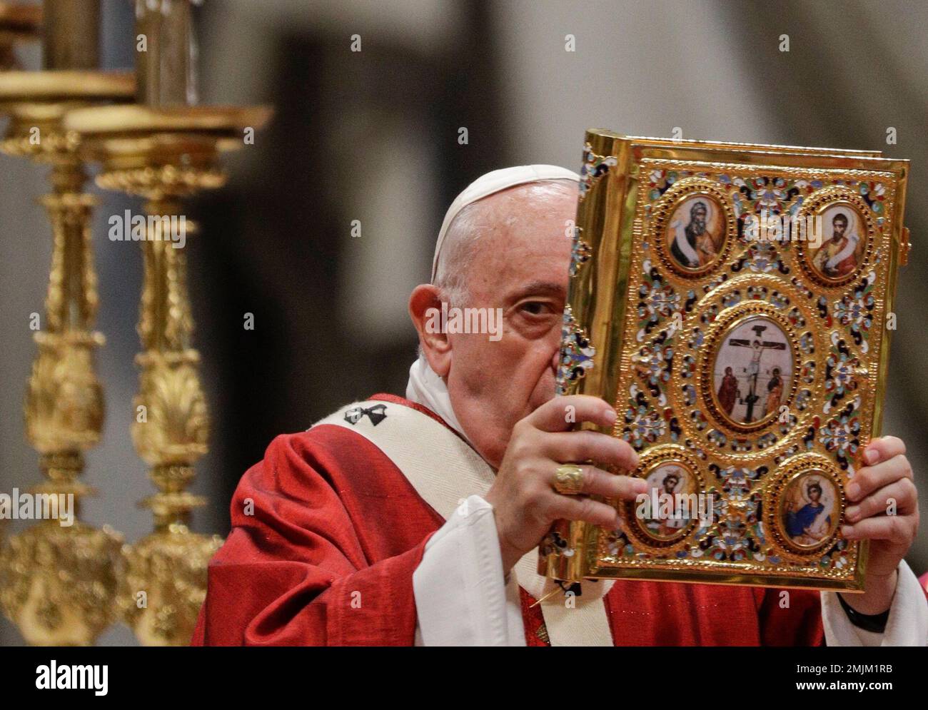 Pope Francis holds the book of Gospels as he celebrates Mass in St ...