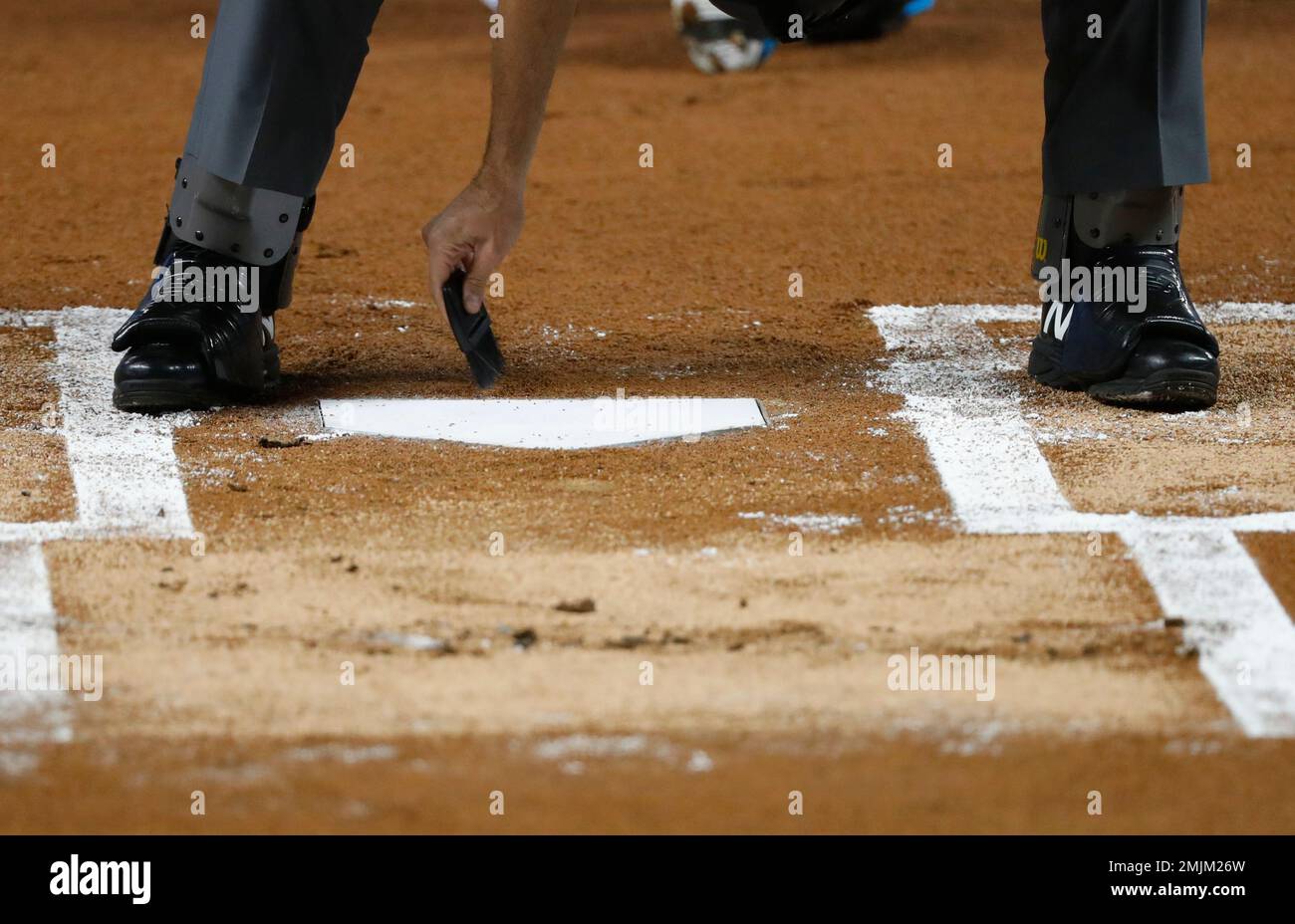 Home plate umpire John Tumpane brushes off home plate before the start ...