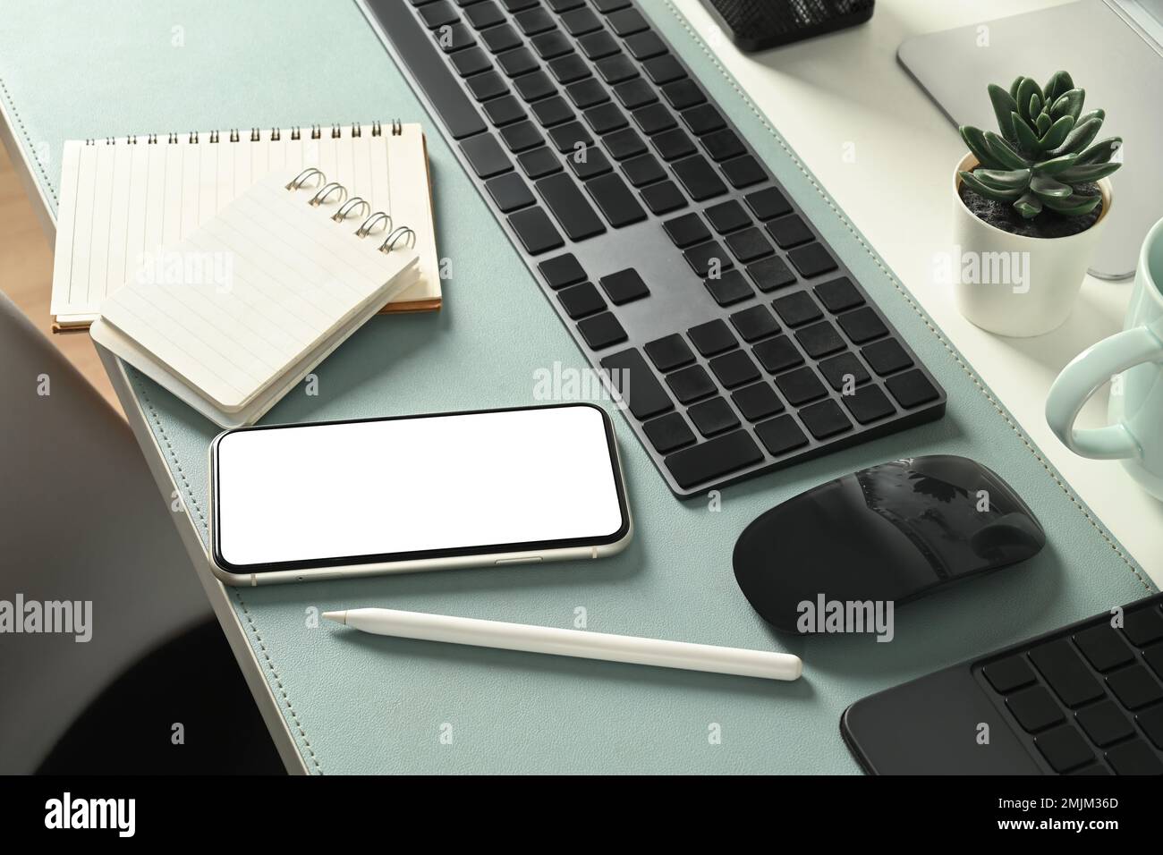 Smart phone with blank screen, notepad, mouse and wireless keyboard on ...