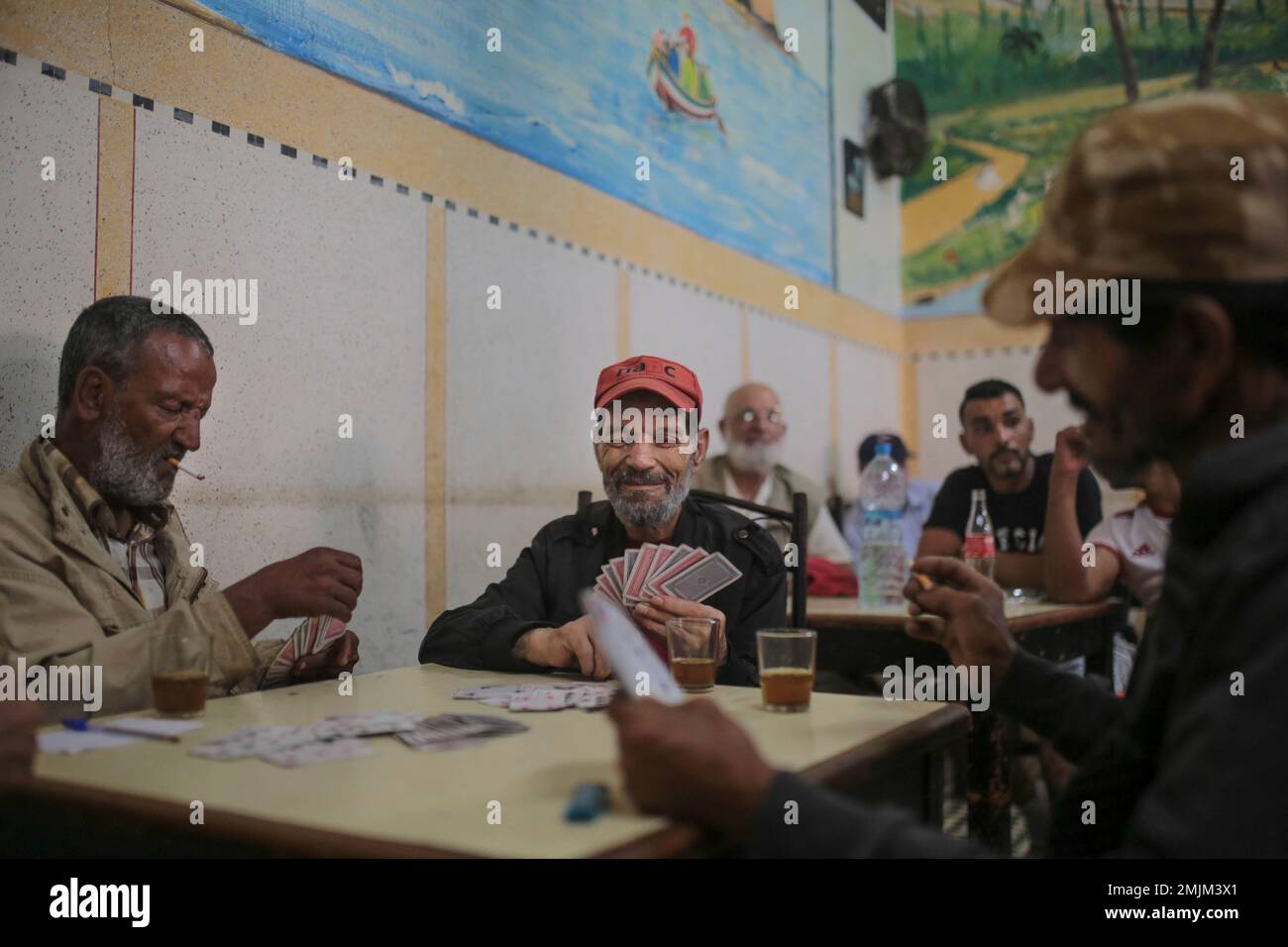 Moroccan men play a game of cards in a coffeeshop in the old Medina of ...