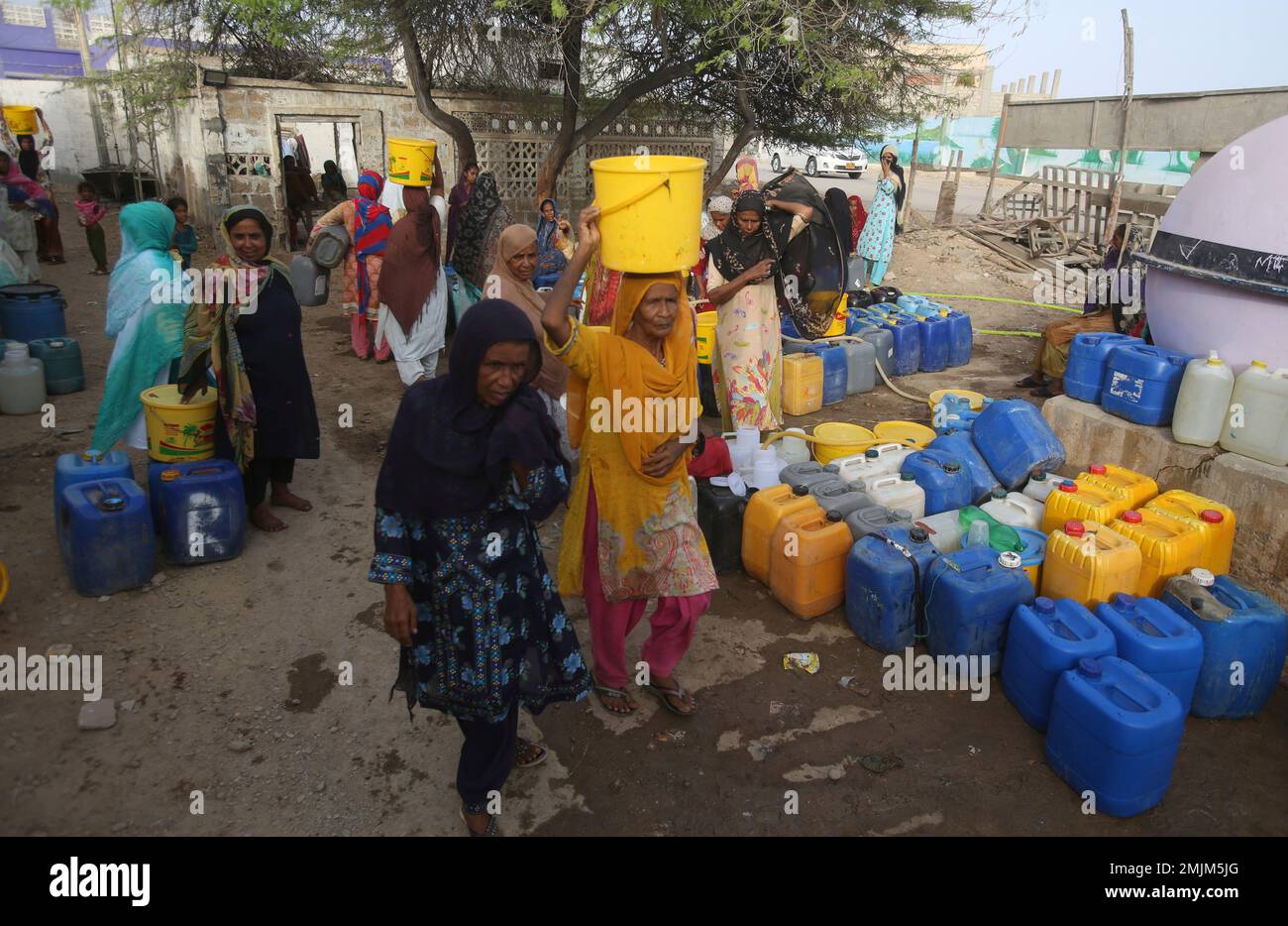 Pakistani women carry clean water for their consumption in Karachi ...