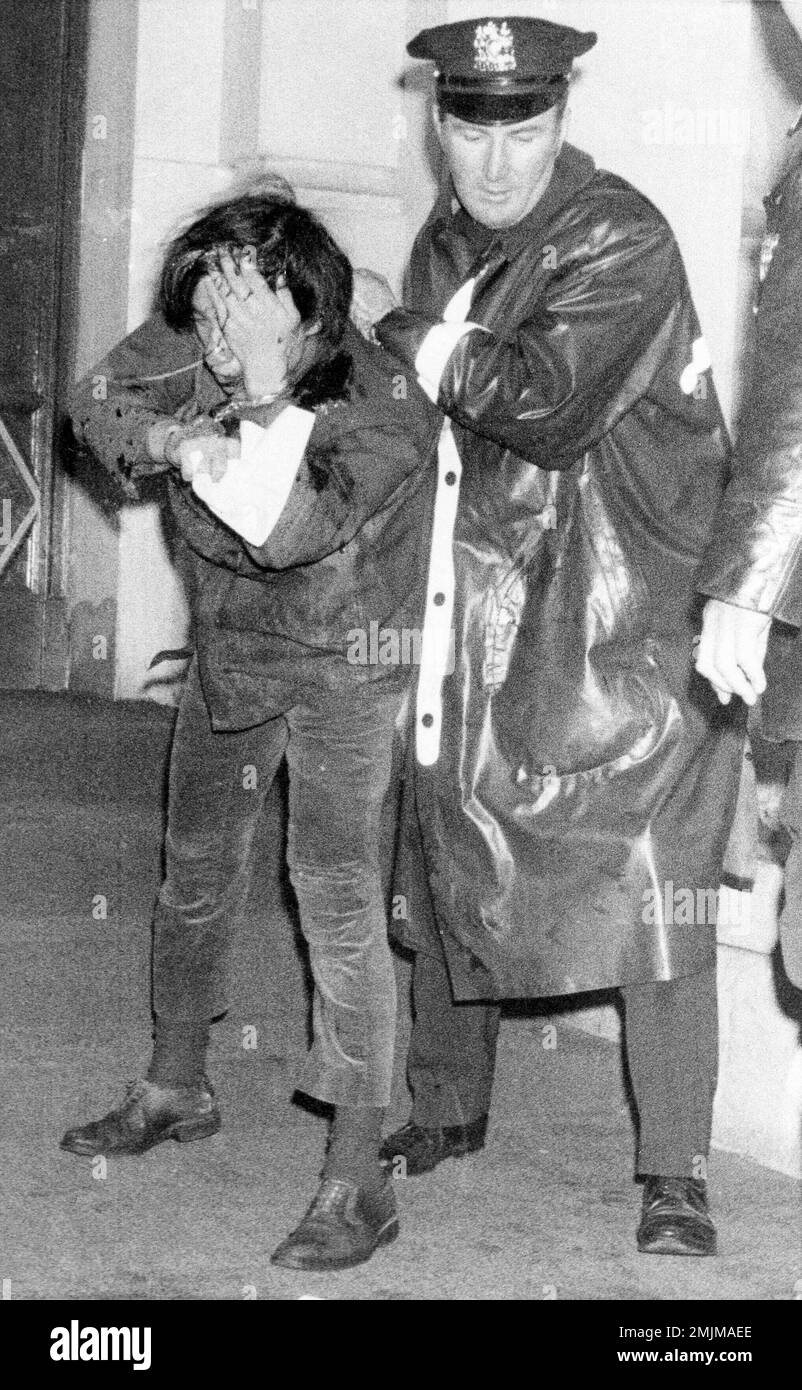 One of two men taken into custody is led by a policeman from the ...