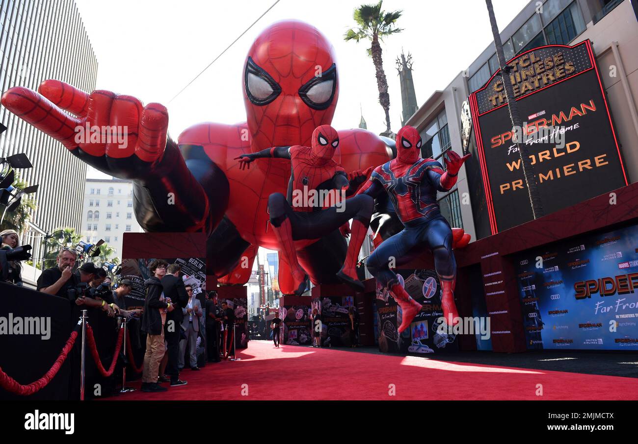 Two Spider-Man characters jump in front of a Spider-Man float at the ...