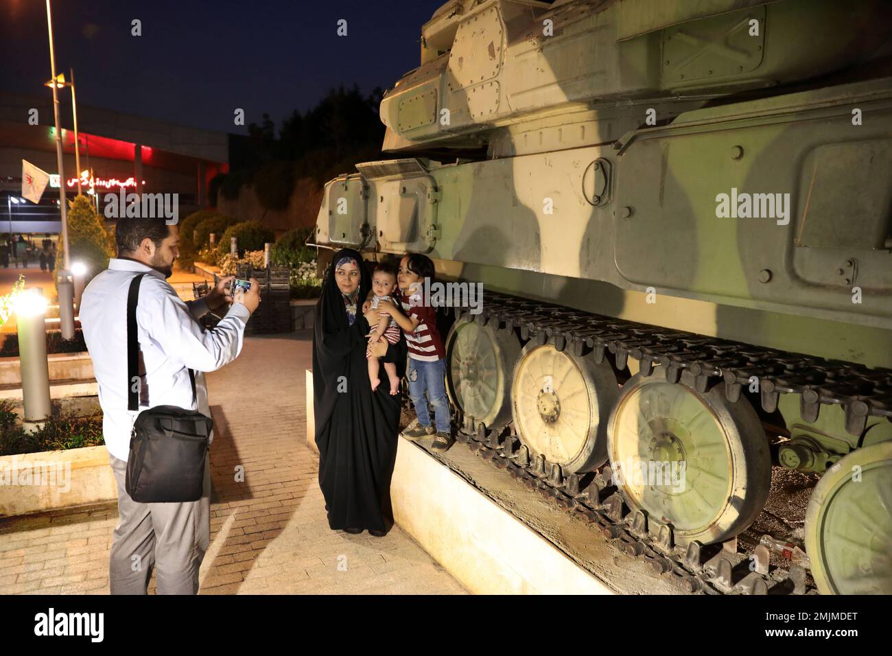 An Iranian family takes memorial picture with a tank at the Islamic ...