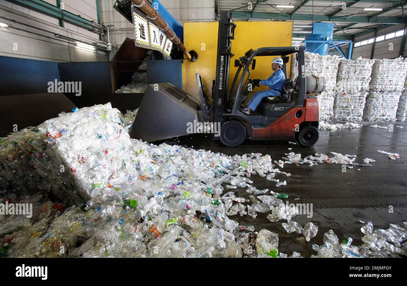 In this June 18, 2019, photo, a plastic recycling company worker on a ...