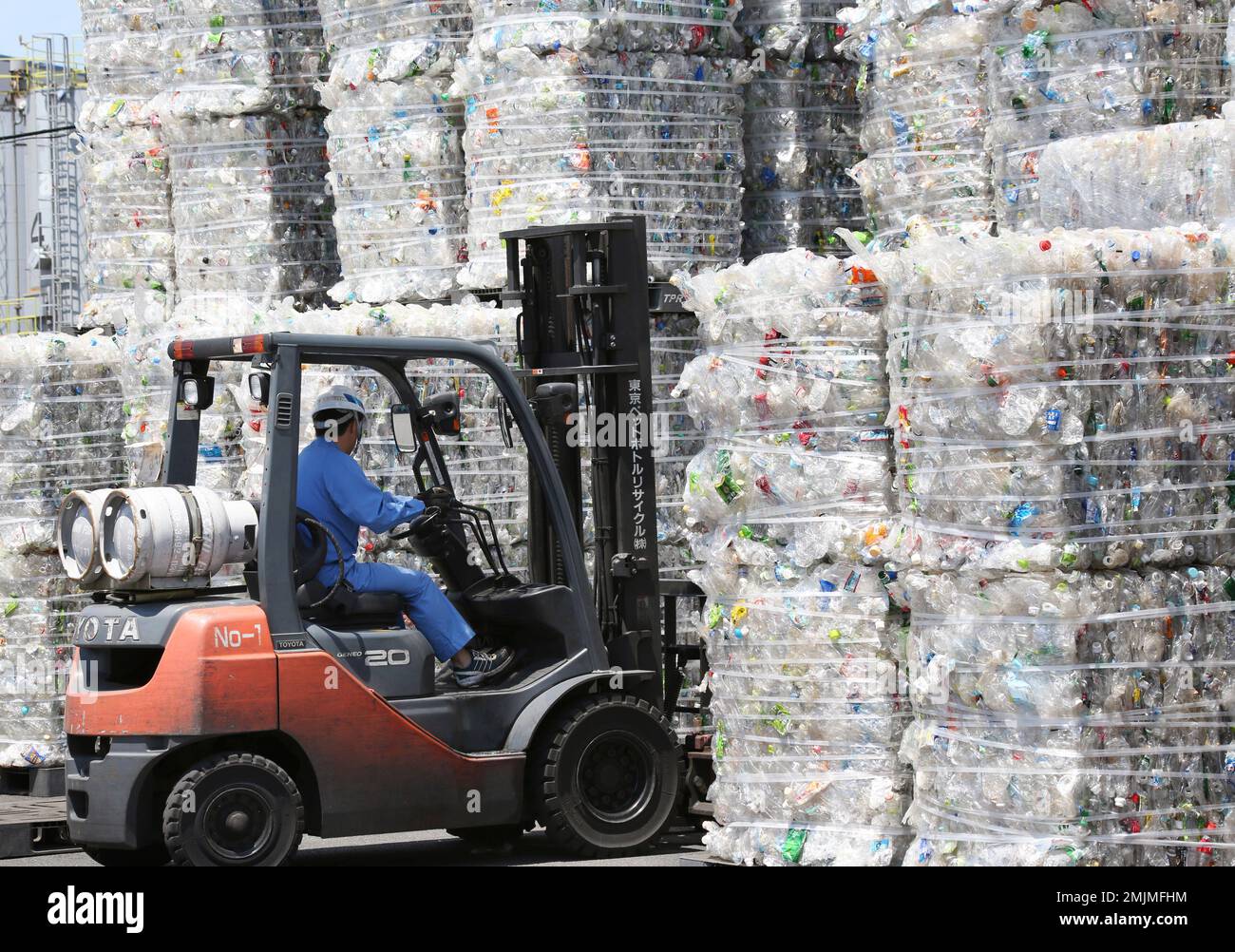 In this June 18, 2019, photo, a plastic recycling company worker on a ...