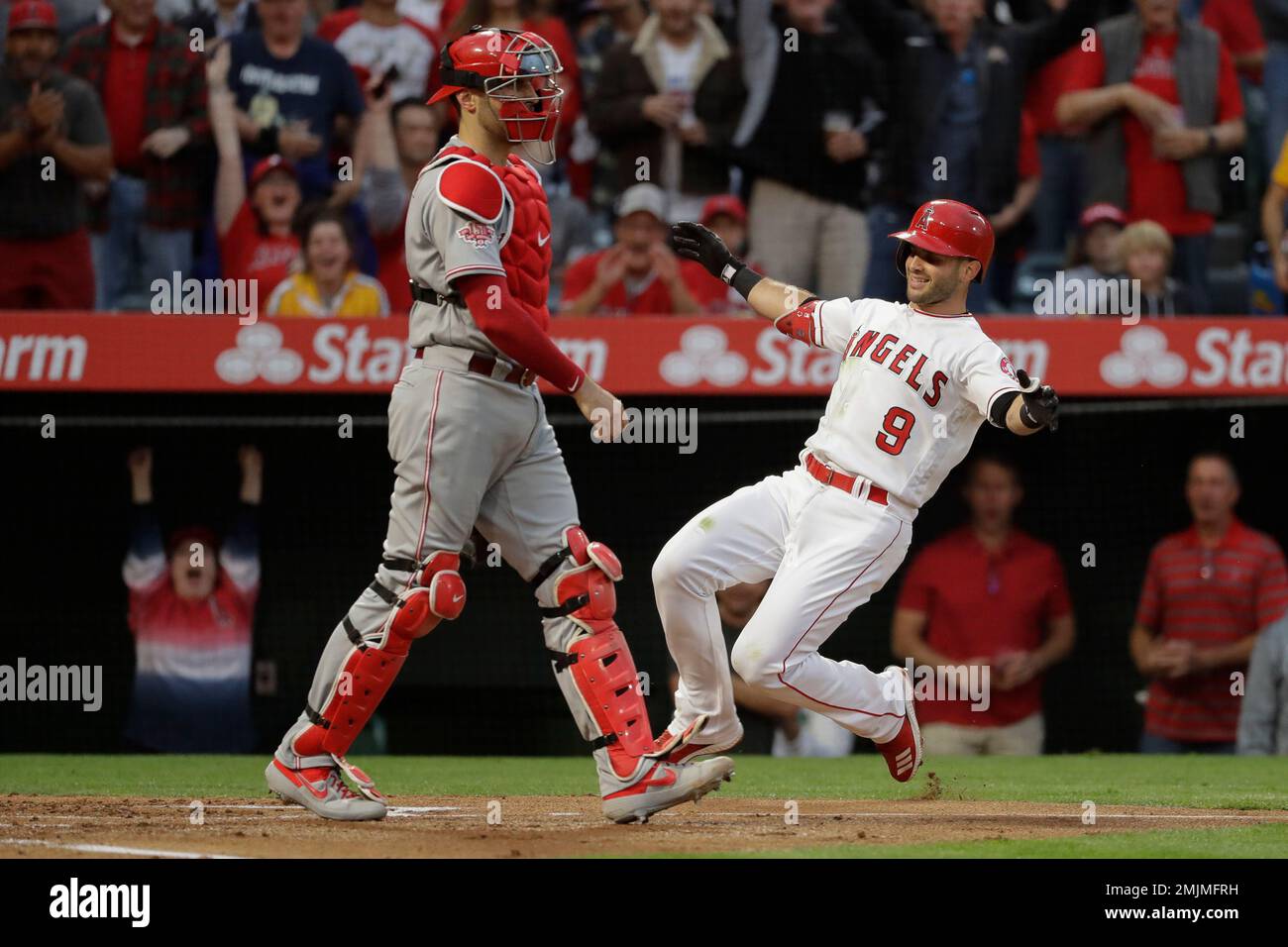 Los Angeles Angels' Tommy La Stella, right, scores past Cincinnati Reds ...