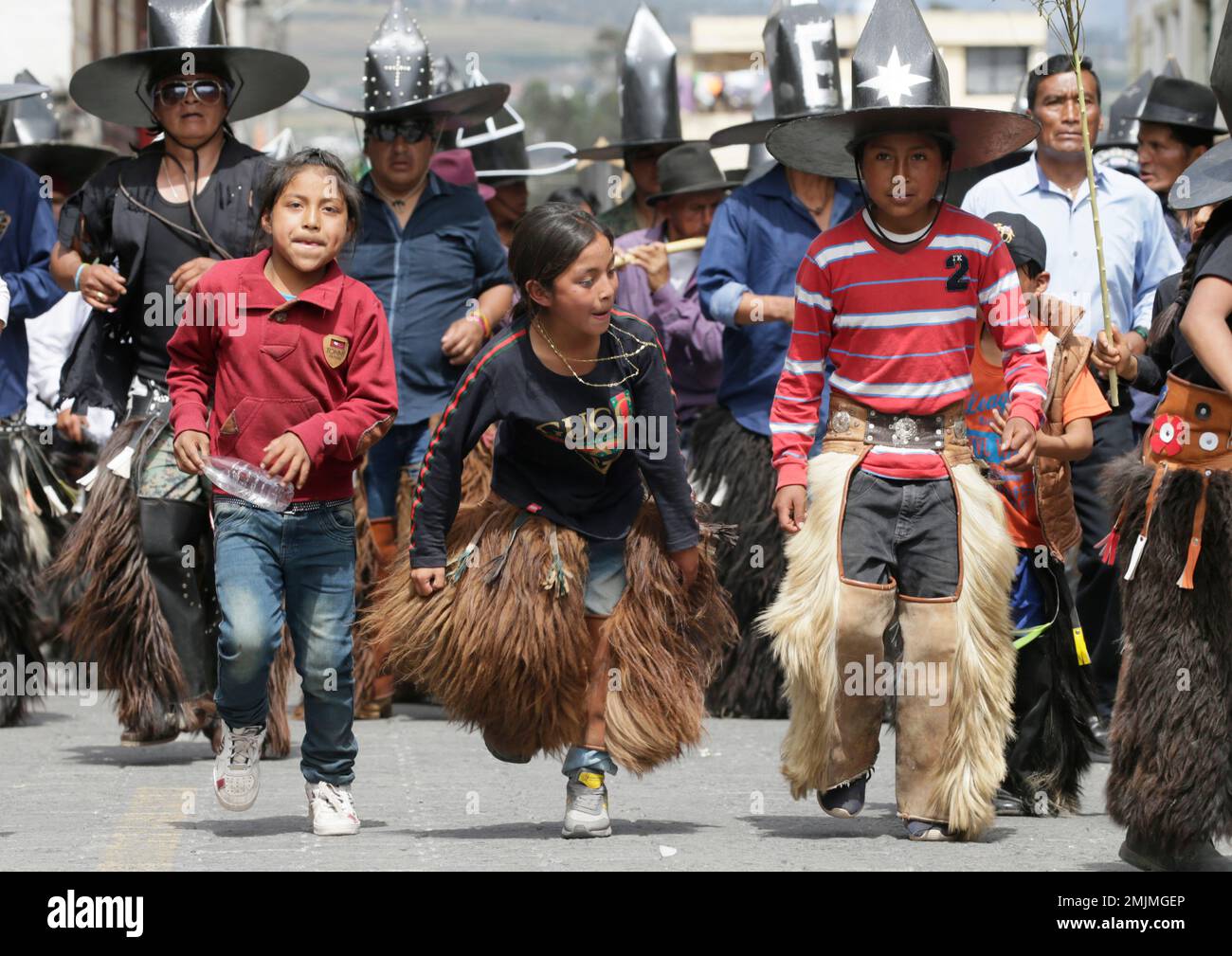 Indigenous men and children, wearing heavy hats that also serve as ...