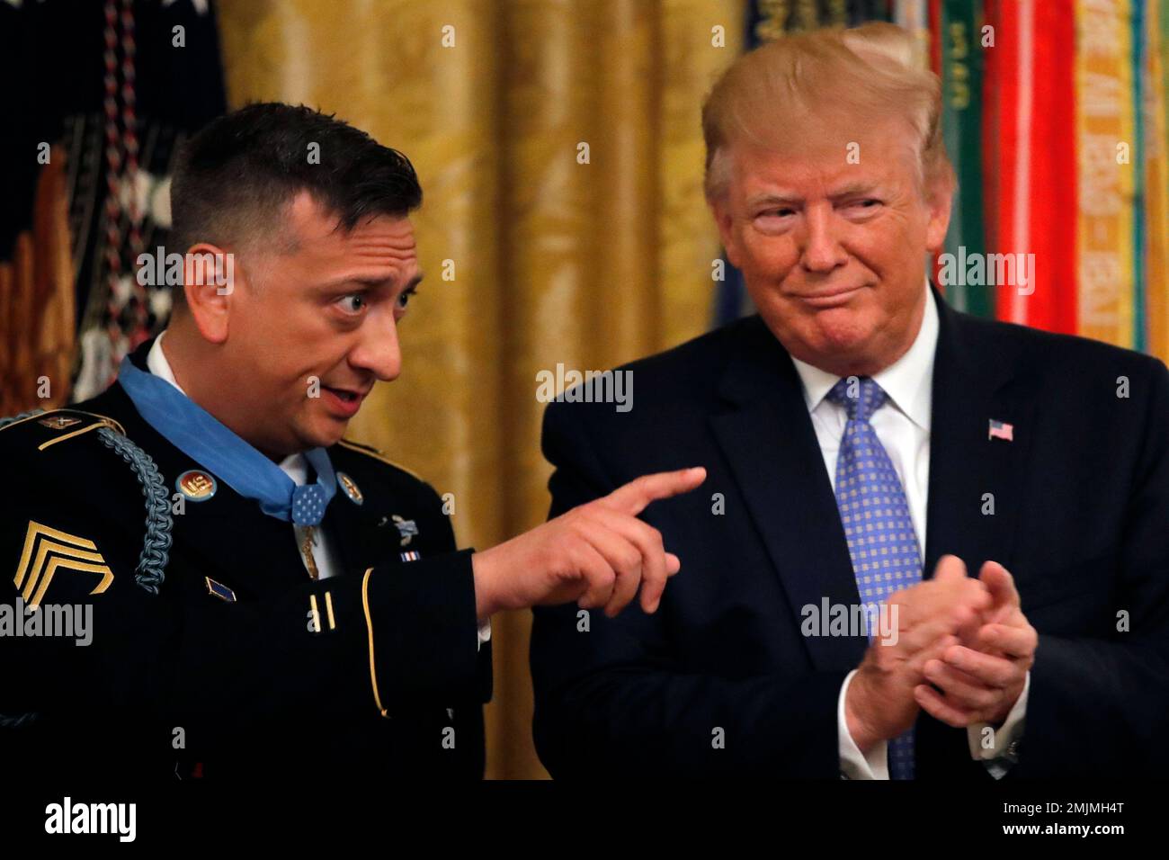 President Donald Trump applauds after awarding Army Staff Sgt. David ...