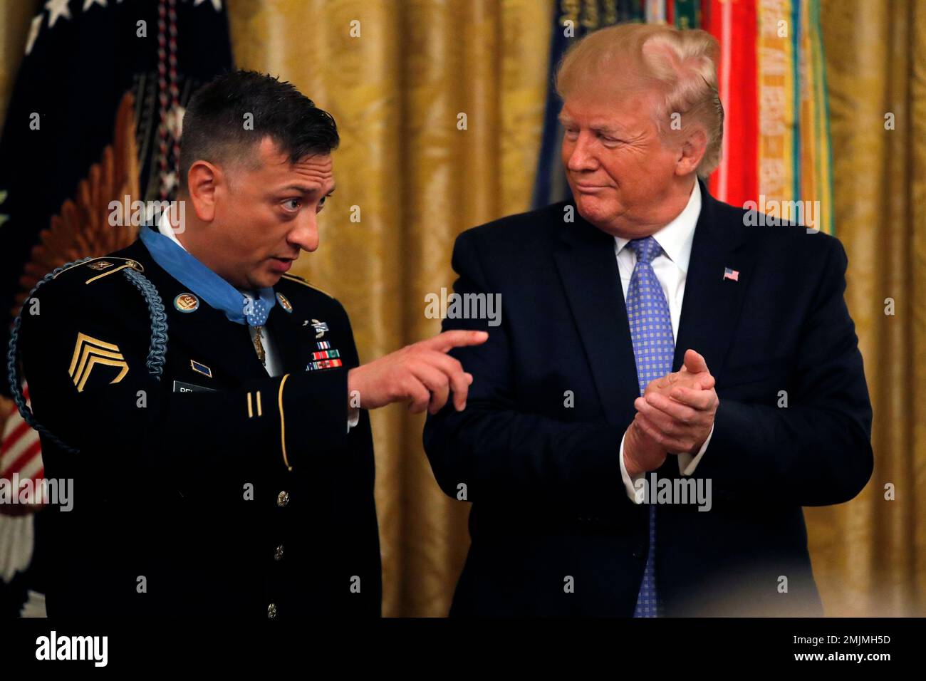 President Donald Trump applauds after awarding Army Staff Sgt. David ...