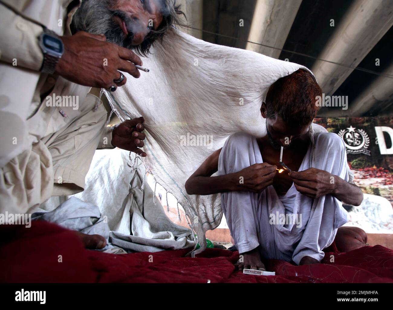 Pakistani drug addicts sitting on a roadside take heroin in Karachi ...