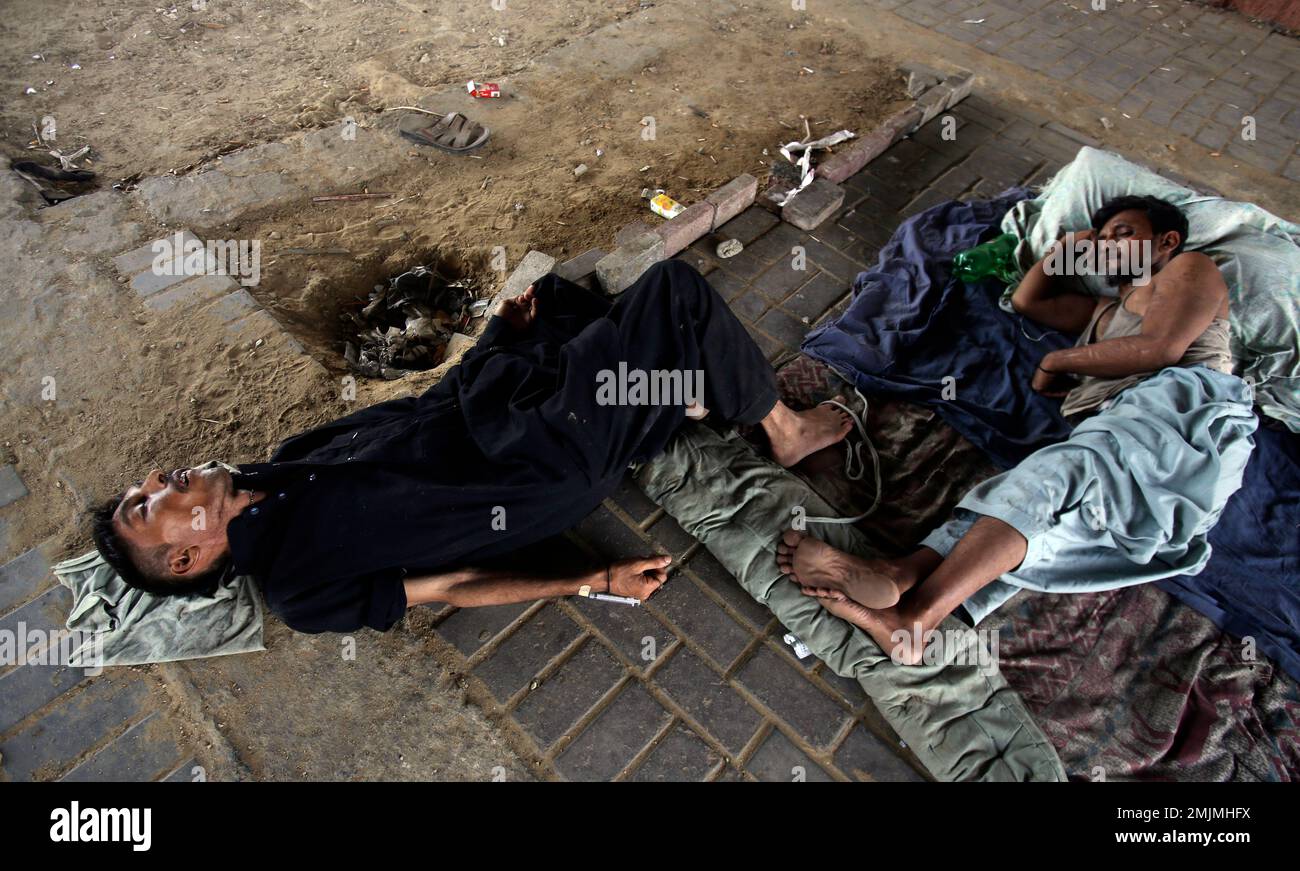 Pakistani drug addicts lie down at a roadside in Karachi, Pakistan ...