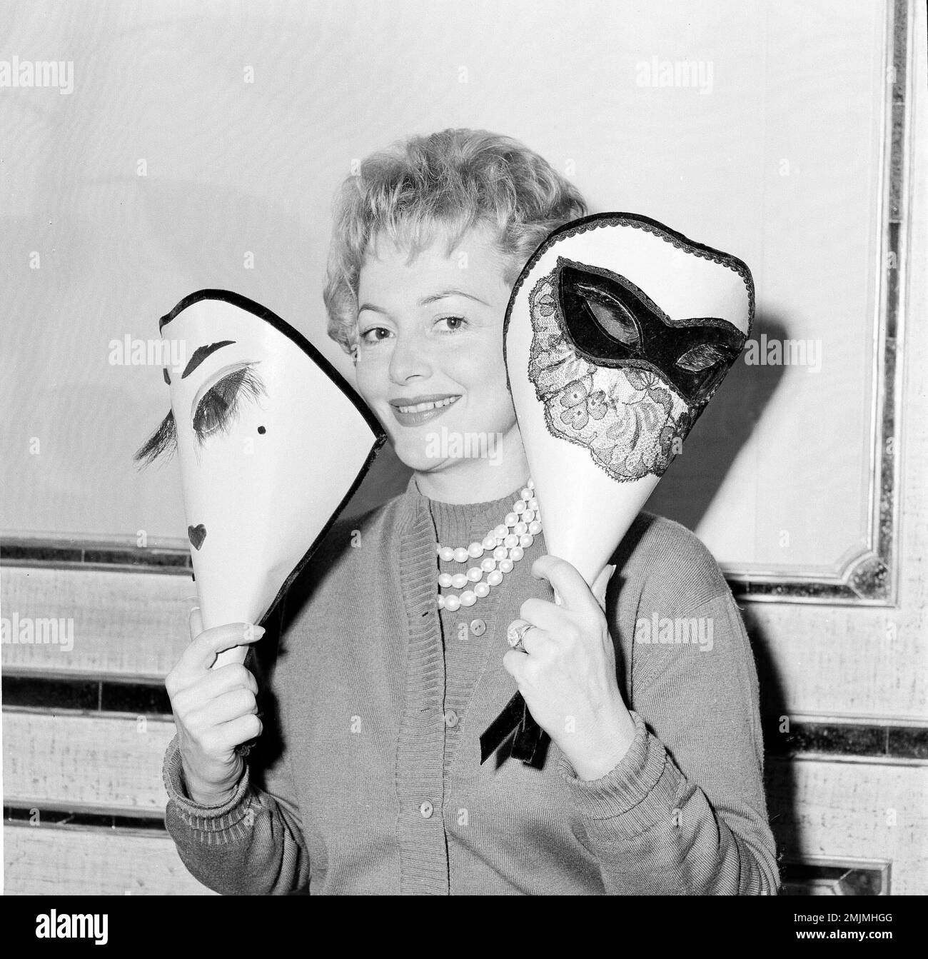American film star Olivia de Havilland holds up a couple of lacquering ...