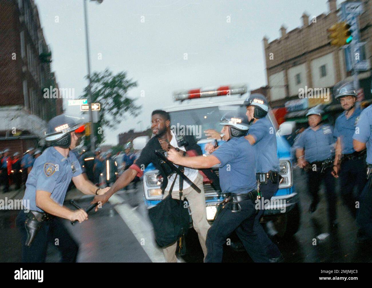 Police arrest a man who was taking pictures during violence between ...