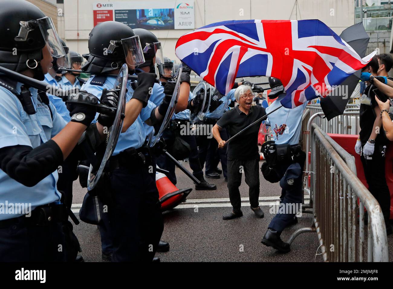 In this Wednesday, June 12, 2019, photo, a woman waves a British flag ...