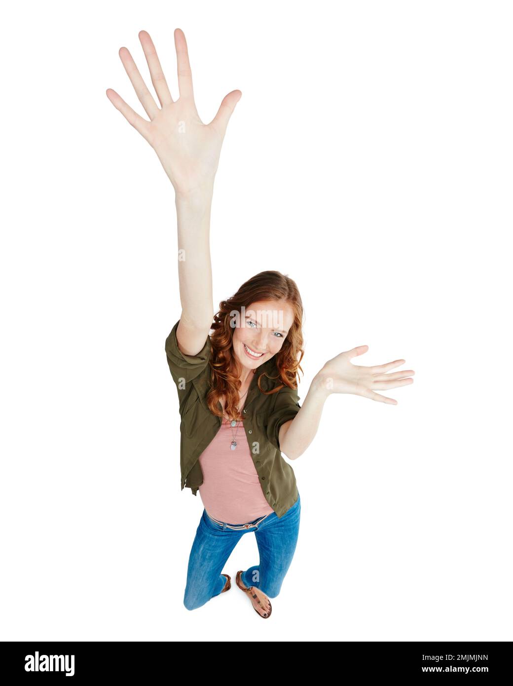 Do the happy dance. a young woman with her arm raised against a white ...