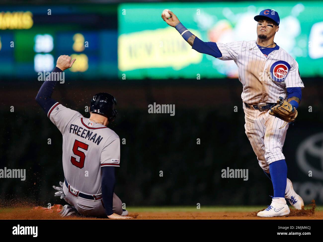 Atlanta Braves' Freddie Freeman, left, is out sliding into second base ...