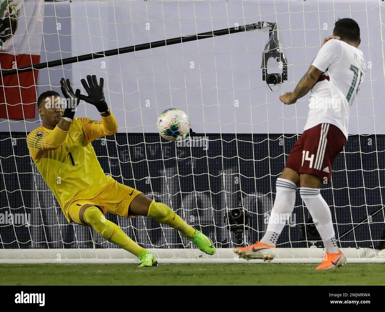 Martinique goalkeeper Loic Chauvet, left, stops a shot by Mexico's ...
