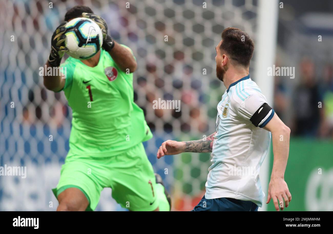 Qatar's goalkeeper Saad Al Sheeb holds the ball as Argentina's Lionel ...