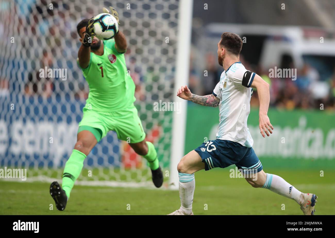 Qatar's goalkeeper Saad Al Sheeb holds the ball as Argentina's Lionel ...