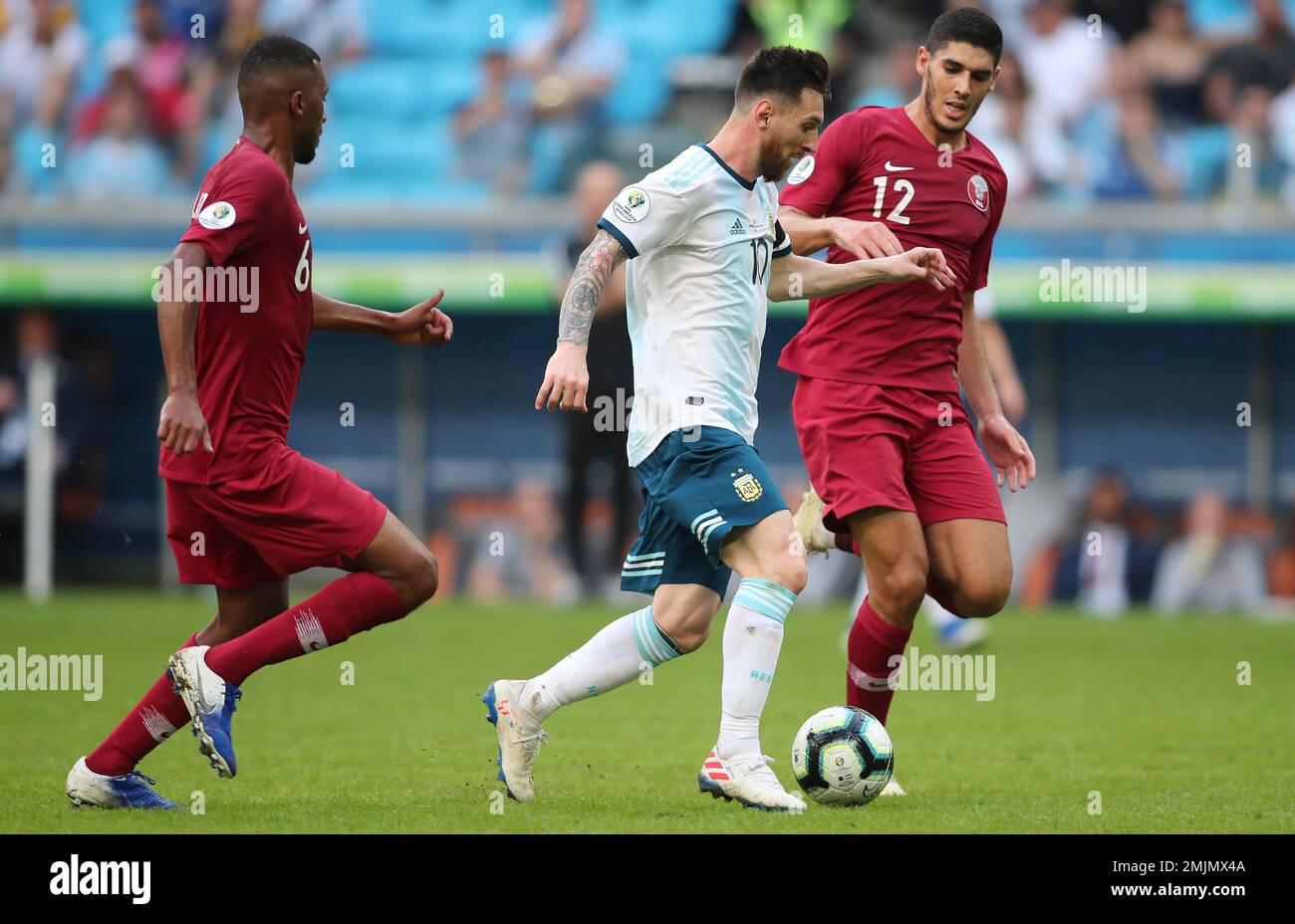 Argentina's Lionel Messi, center, runs past Qatar's Abdulaziz Hatem, left, and Karim Boudiaf ...