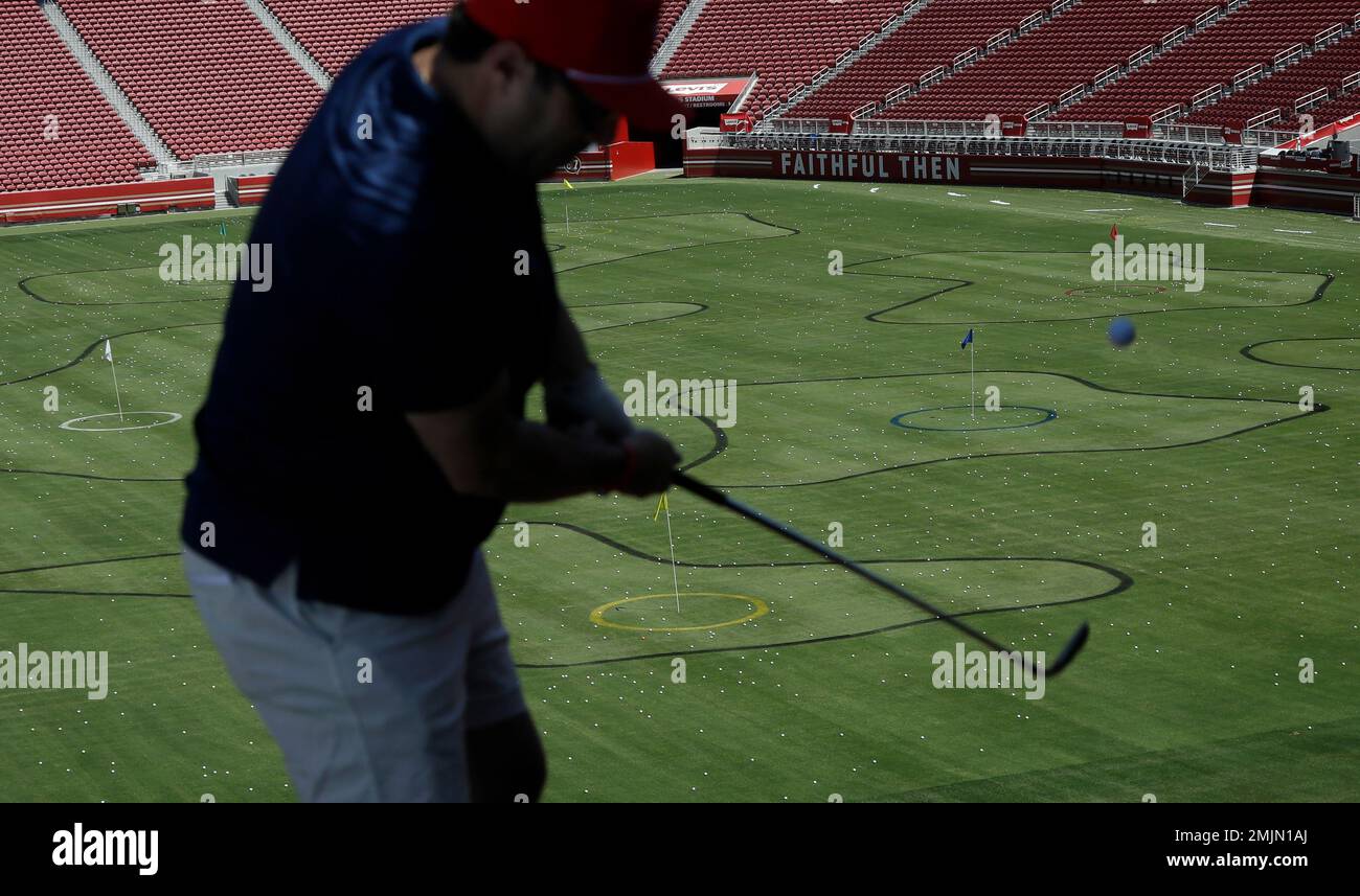 Michael Miano hits a golf ball toward a hole on the field at Levi's ...
