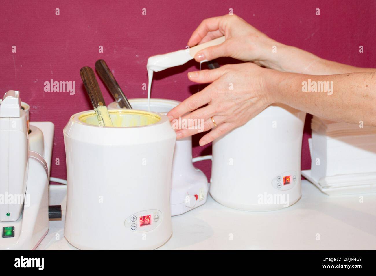 Close up waxing in by the hands of beautician in a spa center Stock ...