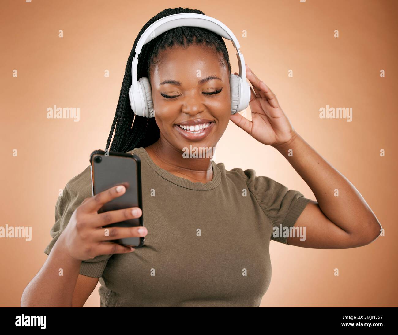 Headphones, smartphone and black woman isolated on studio background ...