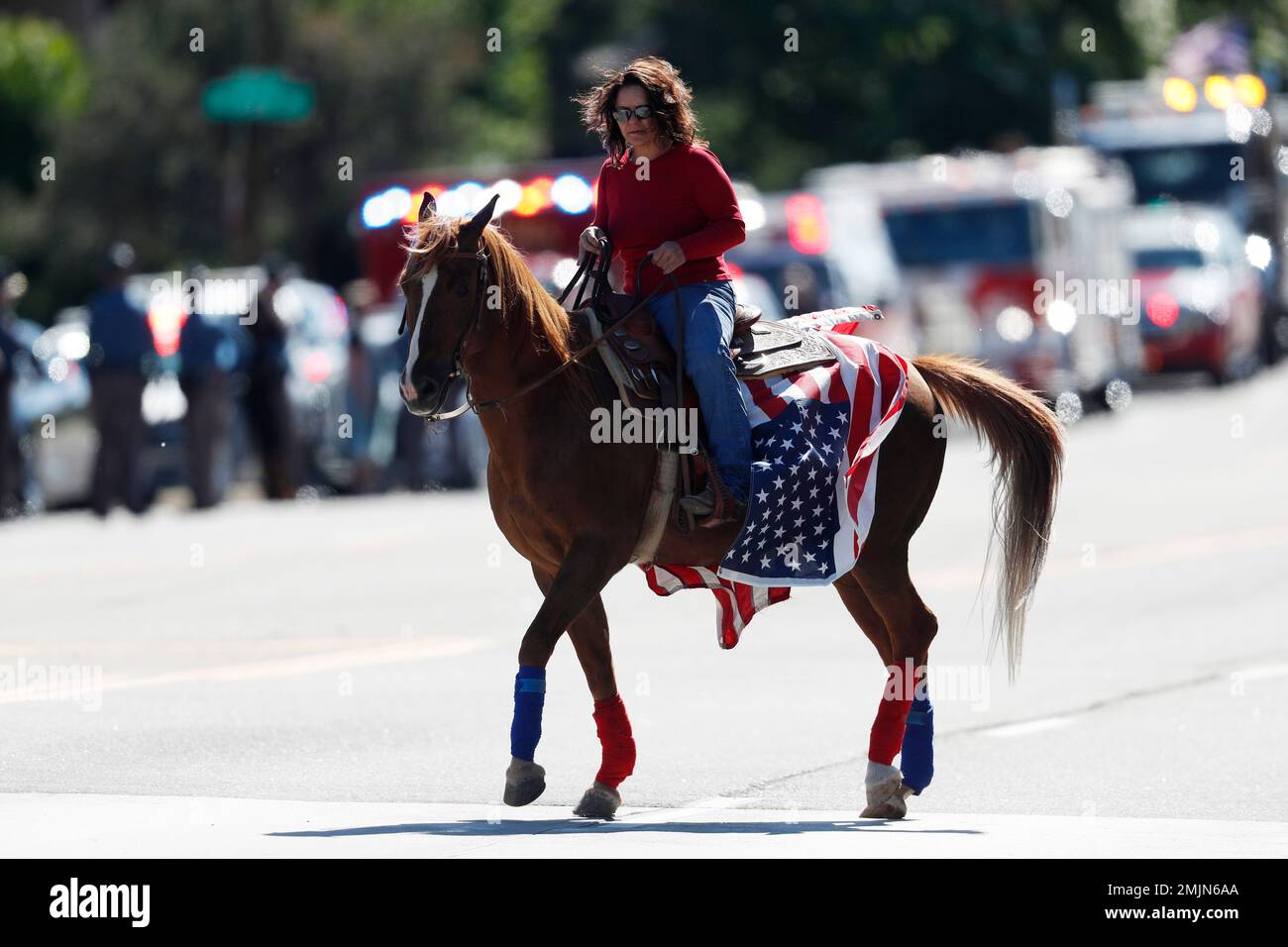 A woman guides her horse down Hampden Avenue as she waits for the ...